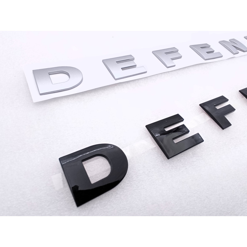 EMBLEMA DELANTERO O TRASERO LETRAS DEFENDER GRIS